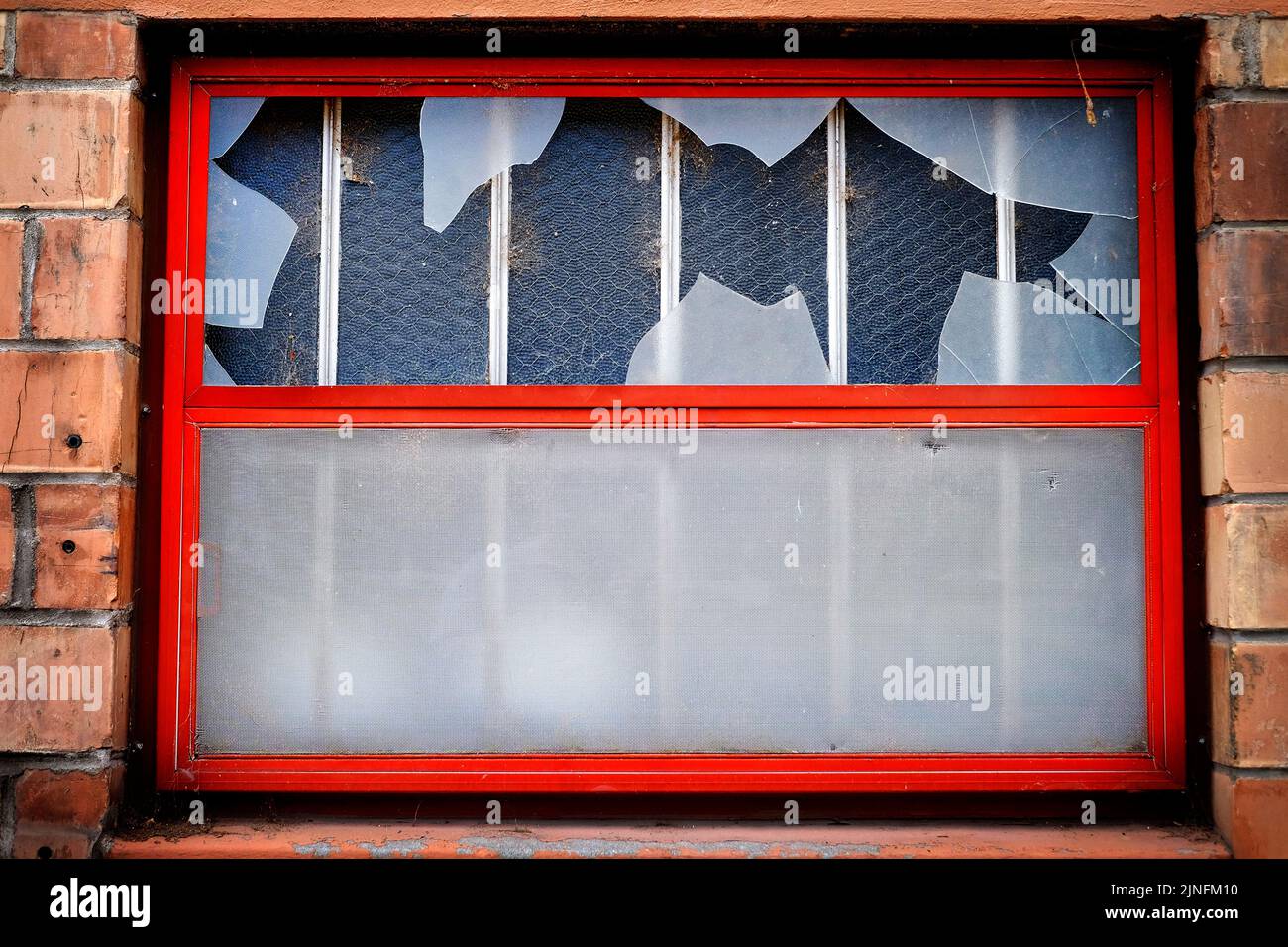 Window on building with broken glass shattered by vandalism destruction ...
