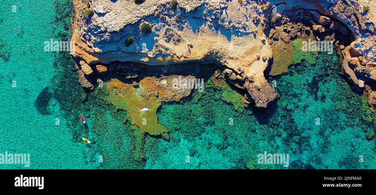 A panoramic aerial view of a lovely blue ocean with a cliffed coast ...