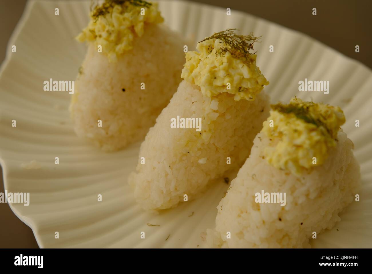 Plate with traditional Japanese onigiri with egg on brown background ...