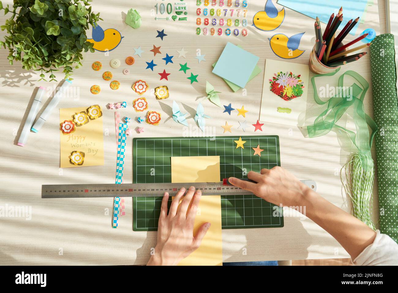 Close-up shot of unrecognizable woman using ruler and cutter knife ...