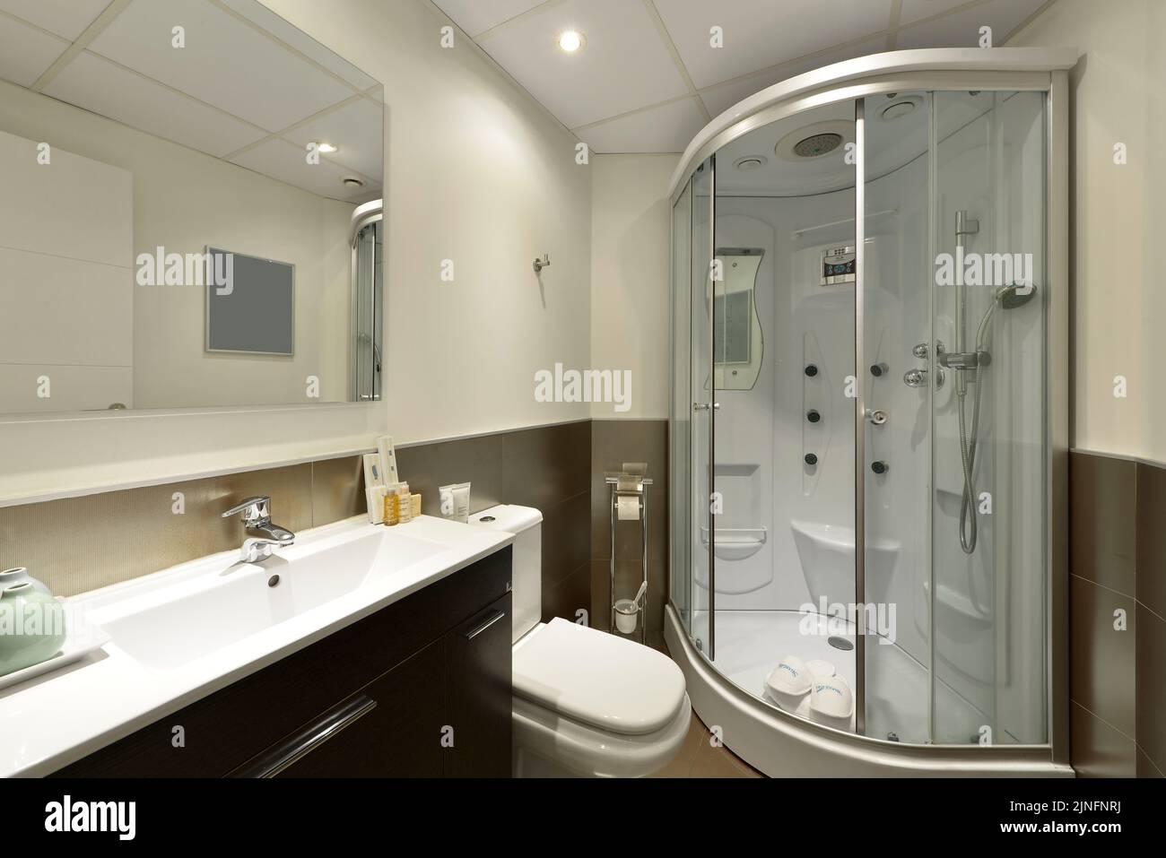 Bathroom with quarter circle shower cubicle with soothing jets ...