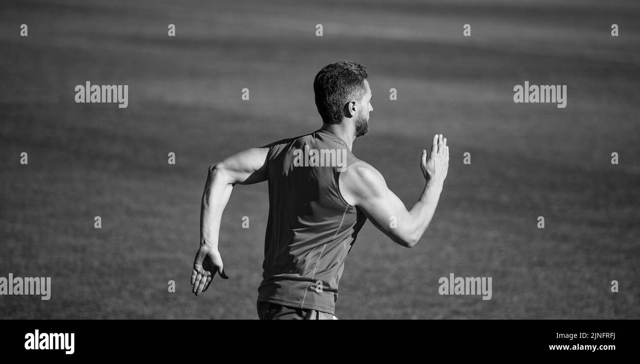 athletic muscular guy running on racetrack at outdoor stadium, motion ...