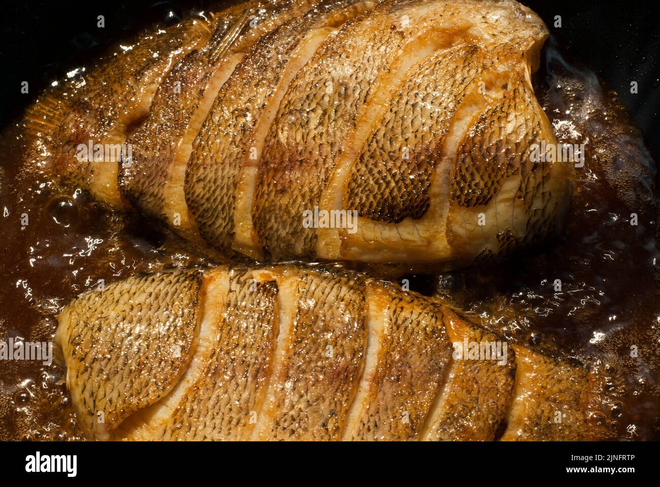 Sun-dried snakeskin gourami, fried in a pan Stock Photo - Alamy