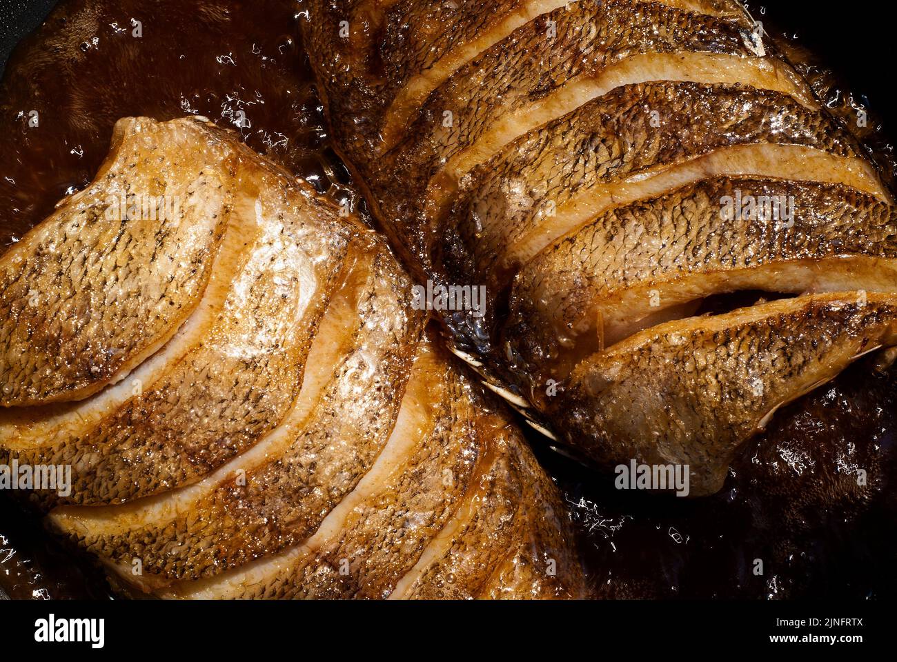 Sun-dried snakeskin gourami, fried in a pan Stock Photo - Alamy