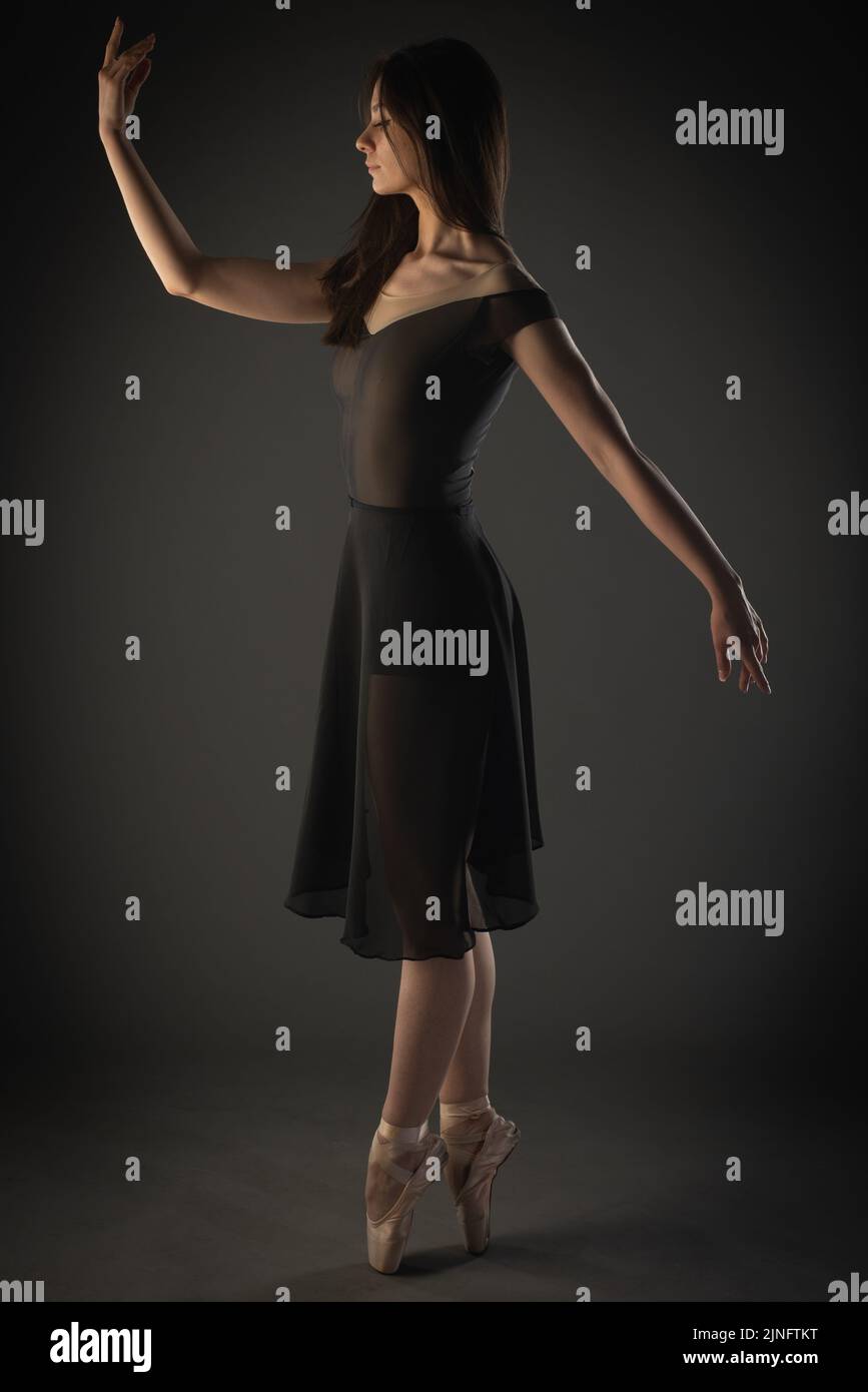 Beautiful abllerina is standing on her pointe shoes in studio on ...