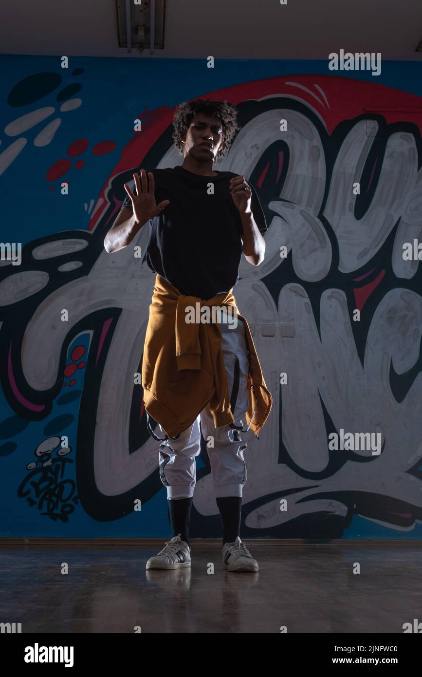 African American hip hop dancer (breakdancer) performing over graffiti ...