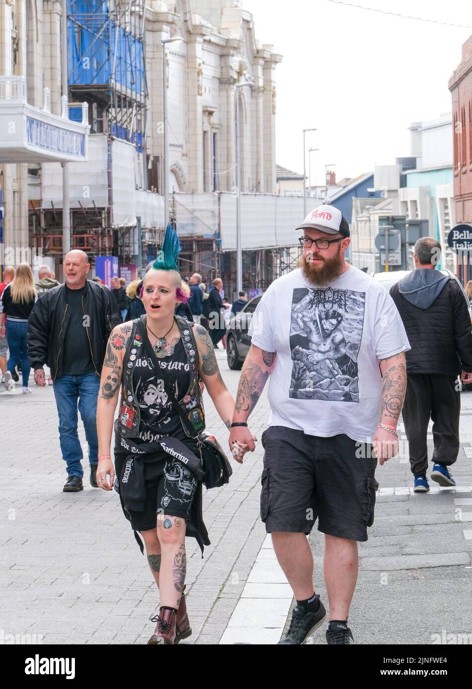 A young couple walk hand in hand up the High St during the Blackpool ...