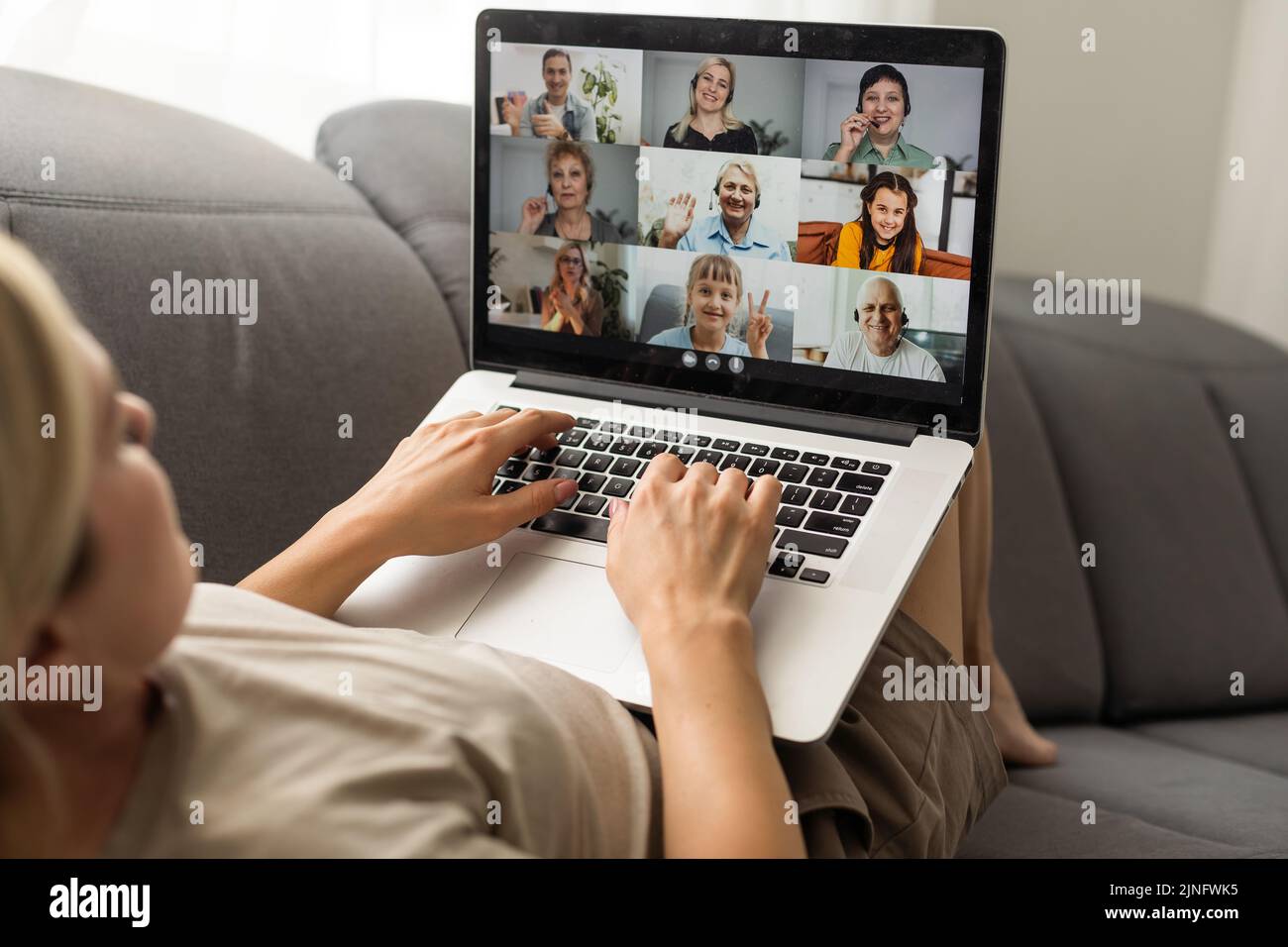 Young woman enjoying video conversation via laptop with eldery mother ...