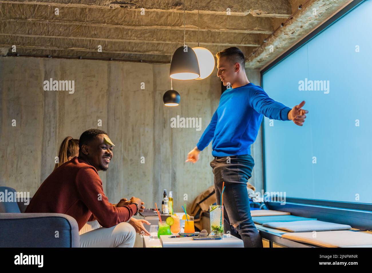 Multiracial friends are laughing while one of them is acting crazy ...