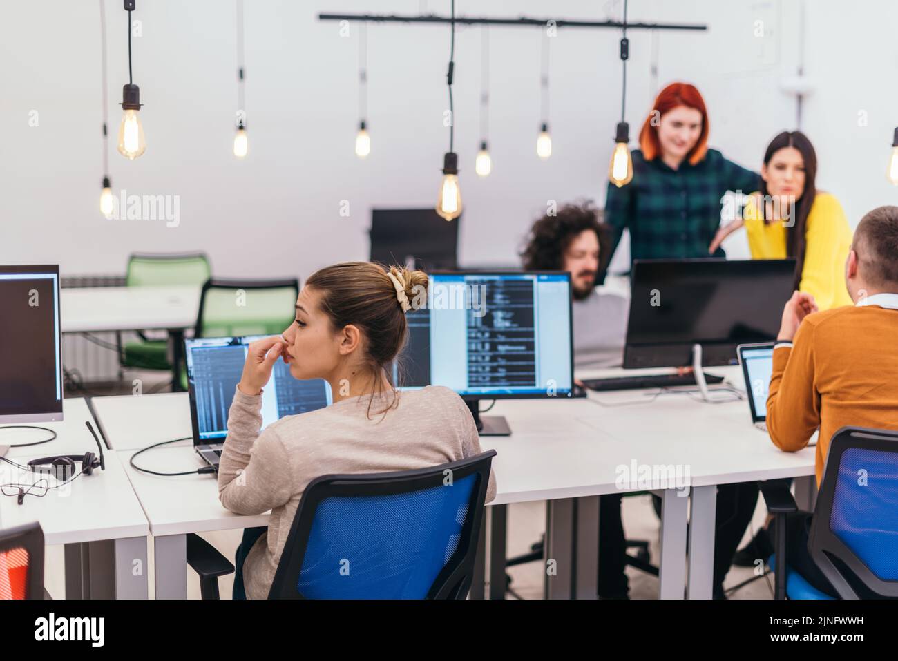 Group of multi-ethnic colleagues working on desktop computers in a ...