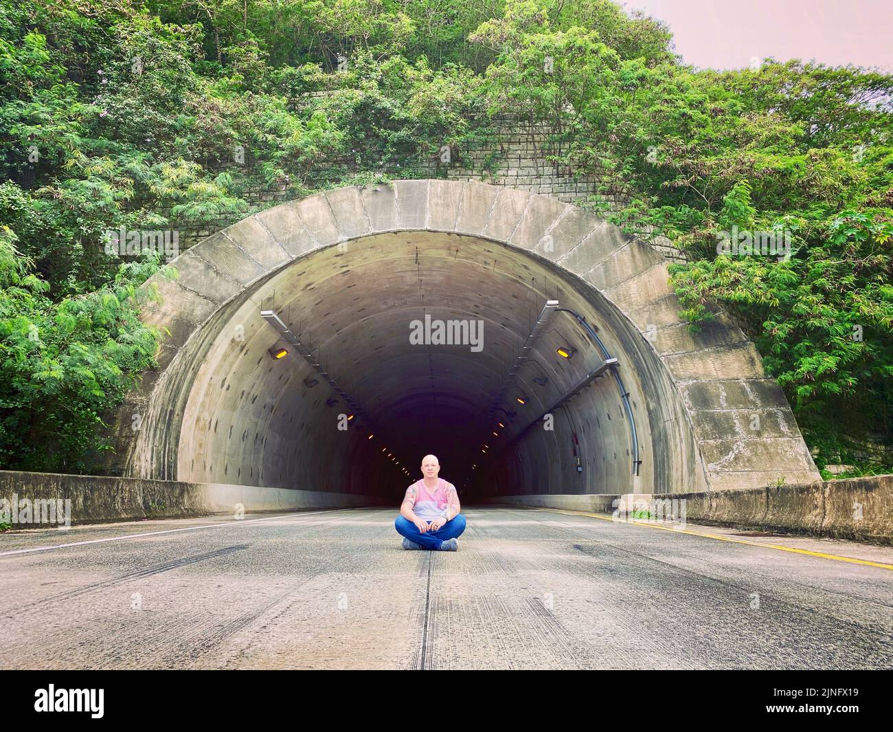 A Hispanic man sitting on the road in front of a tunnel in Puerto Rico ...