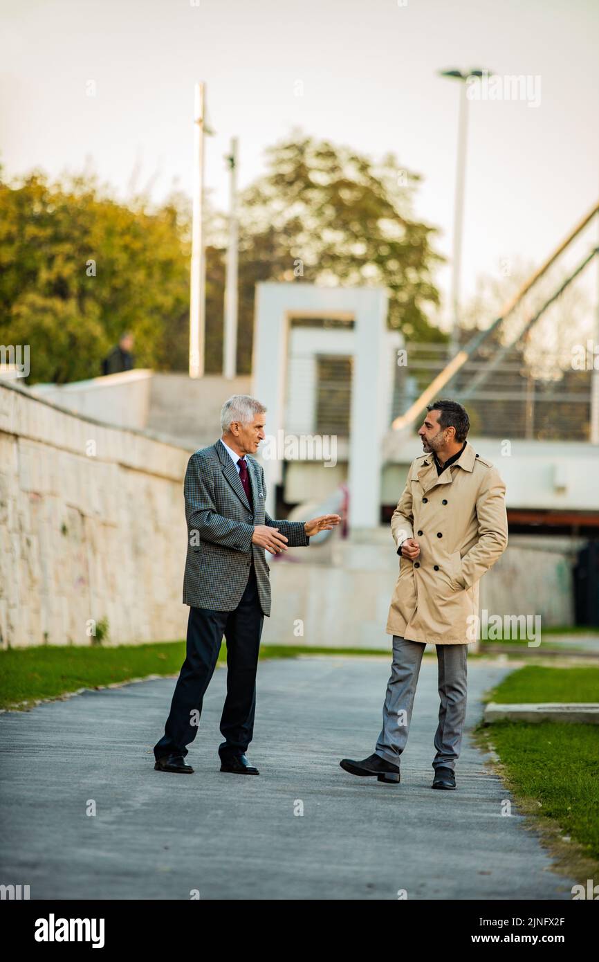 Two amazinf senior businessmen are standing and talking Stock Photo - Alamy