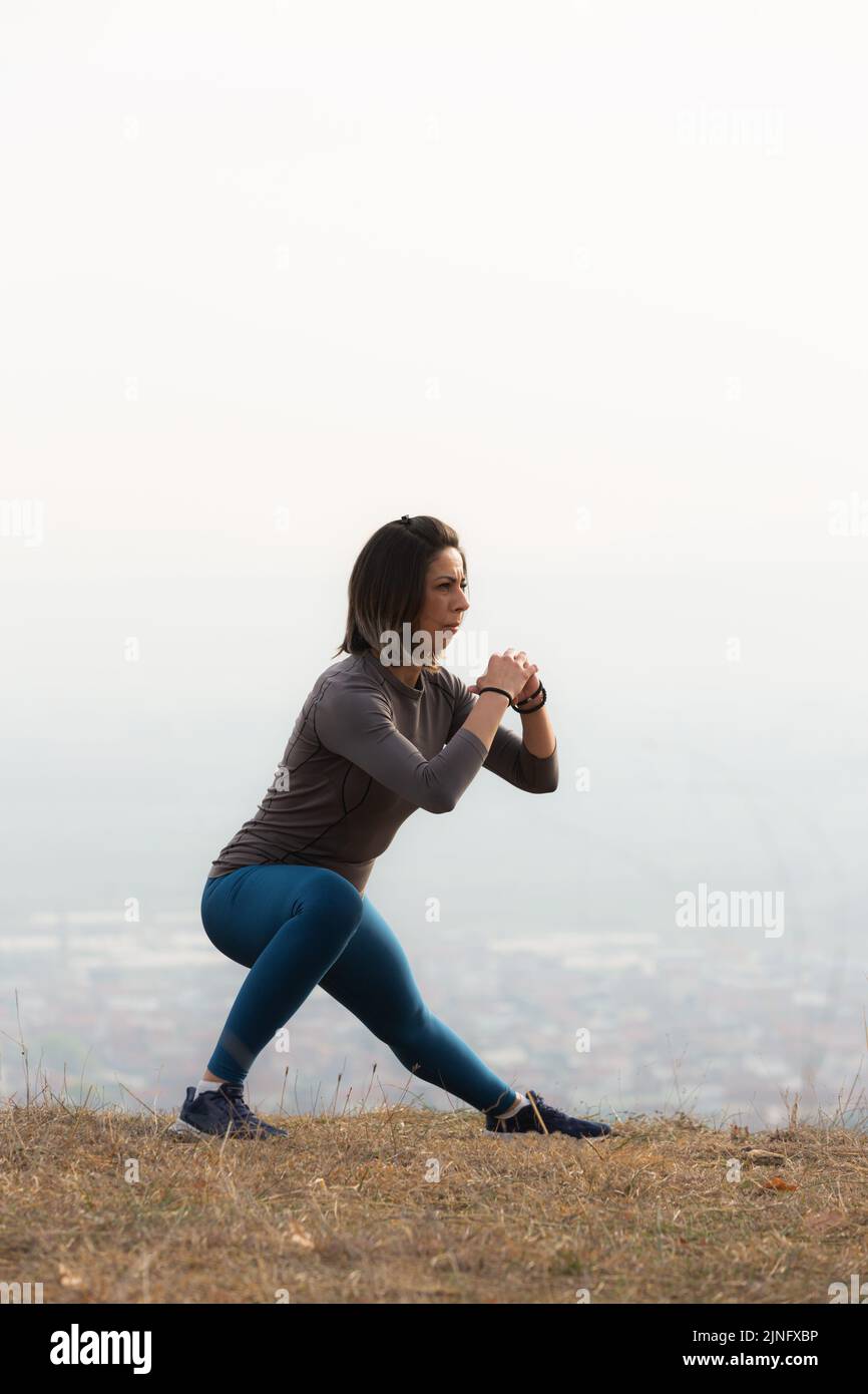 Amazing and active woman is stretching her legs Stock Photo - Alamy
