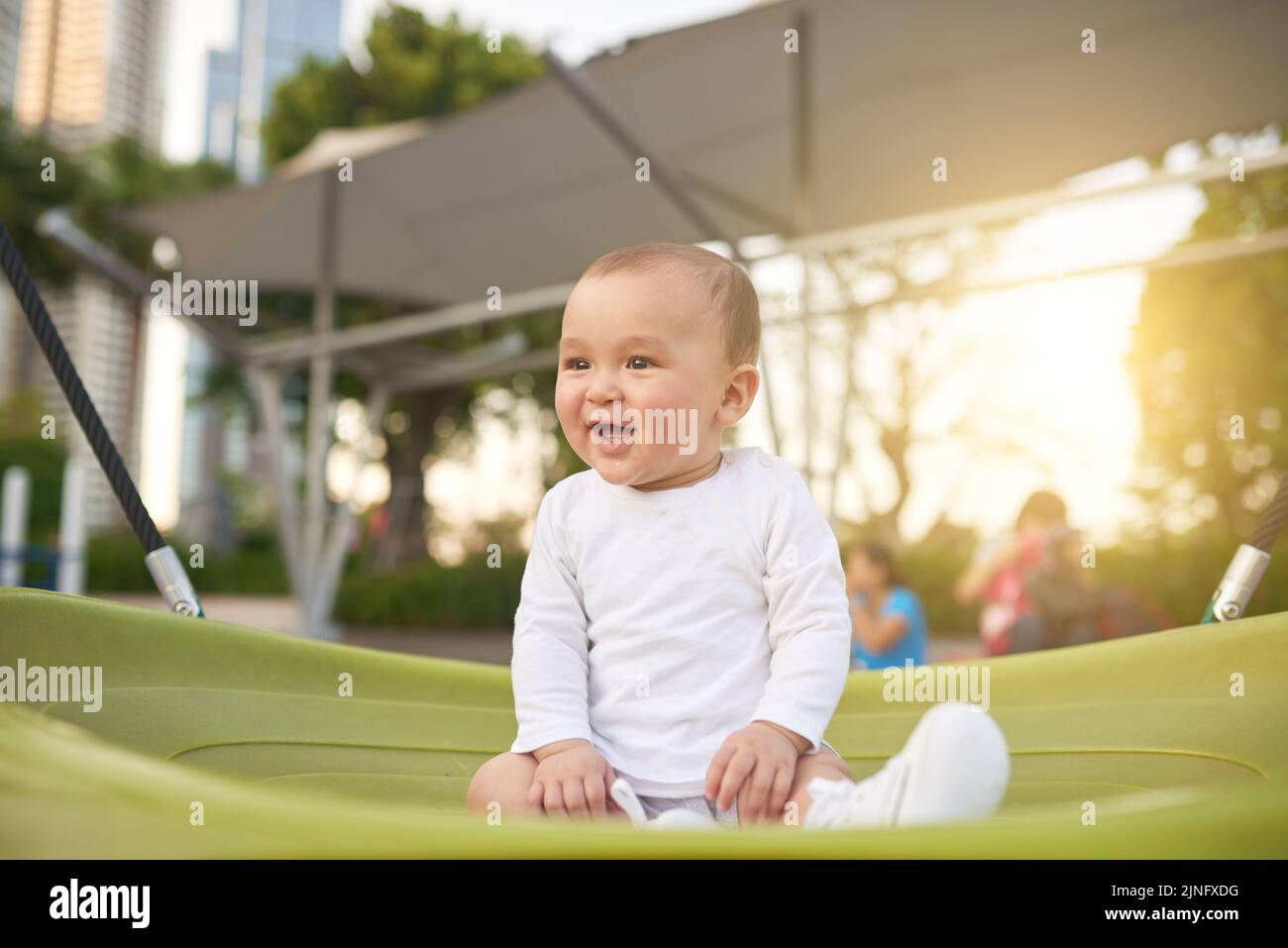 Playful little baby enjoying spending time on swing Stock Photo - Alamy