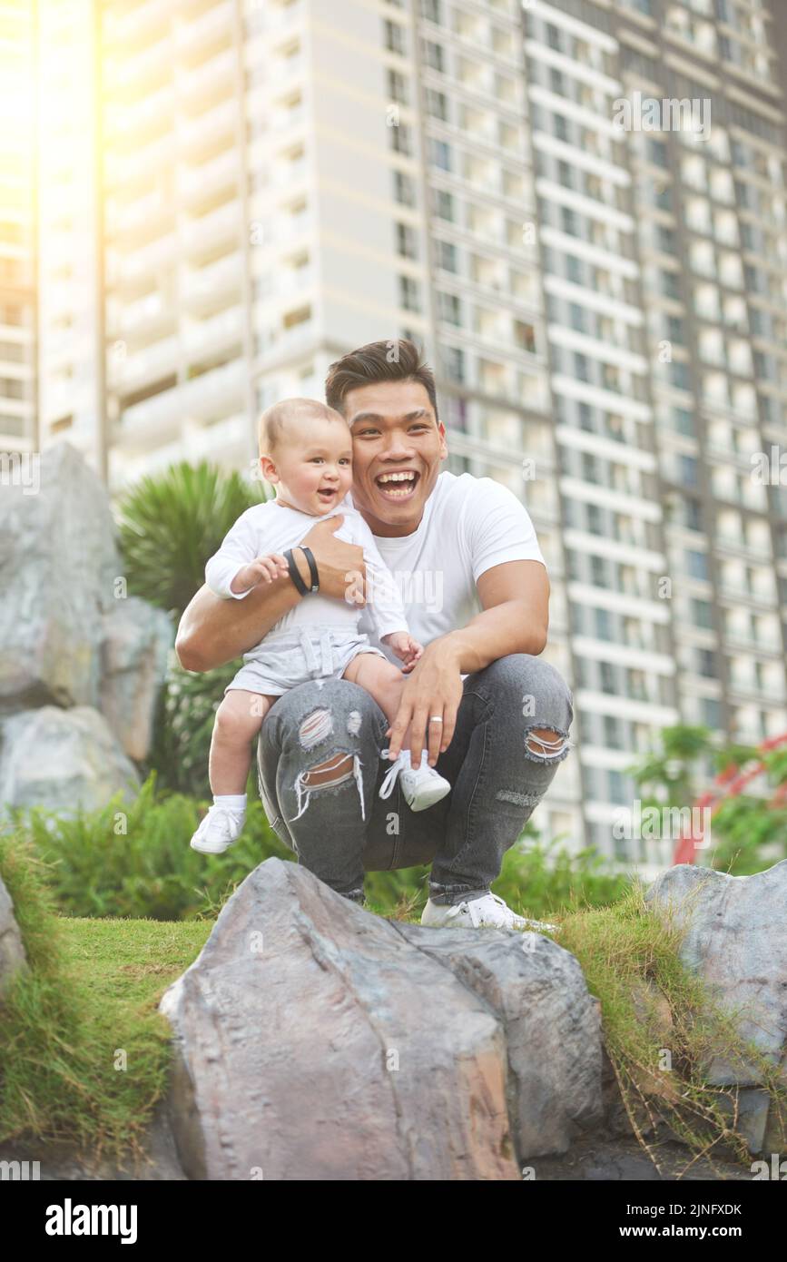 Happy excited young Vietnamese man playing outdoor with his baby Stock ...