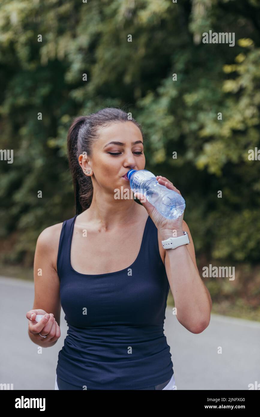 Female athlete drinking water, refreshing, hydrating after a long exhausting workout, run Stock ...