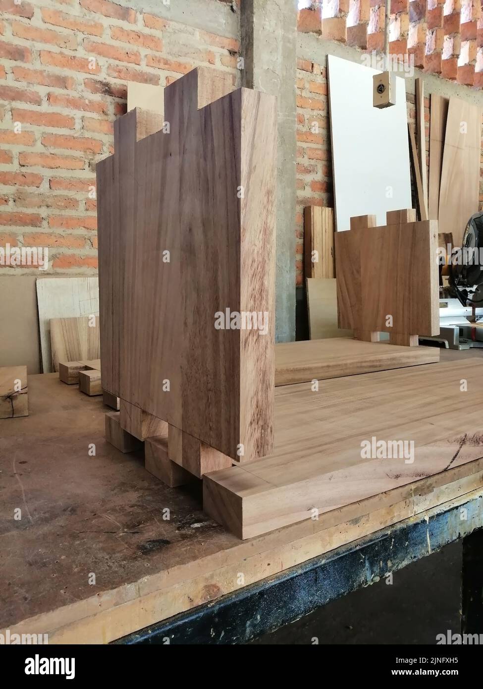 A vertical shot of wood pieces in jagged forms with dovetail attachment ...