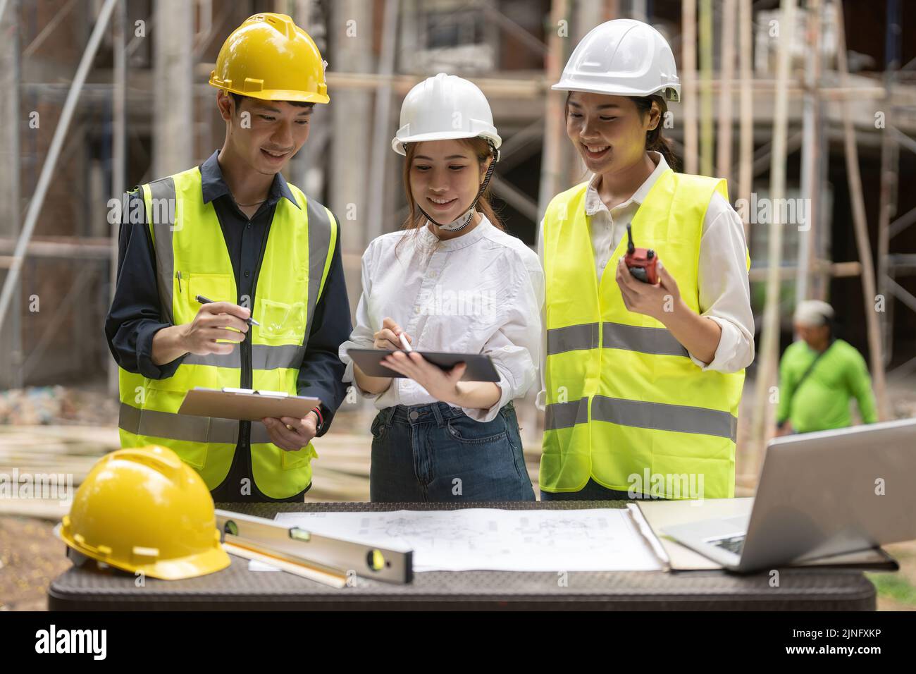 architector and engineers with draft plan of building and tablet ...