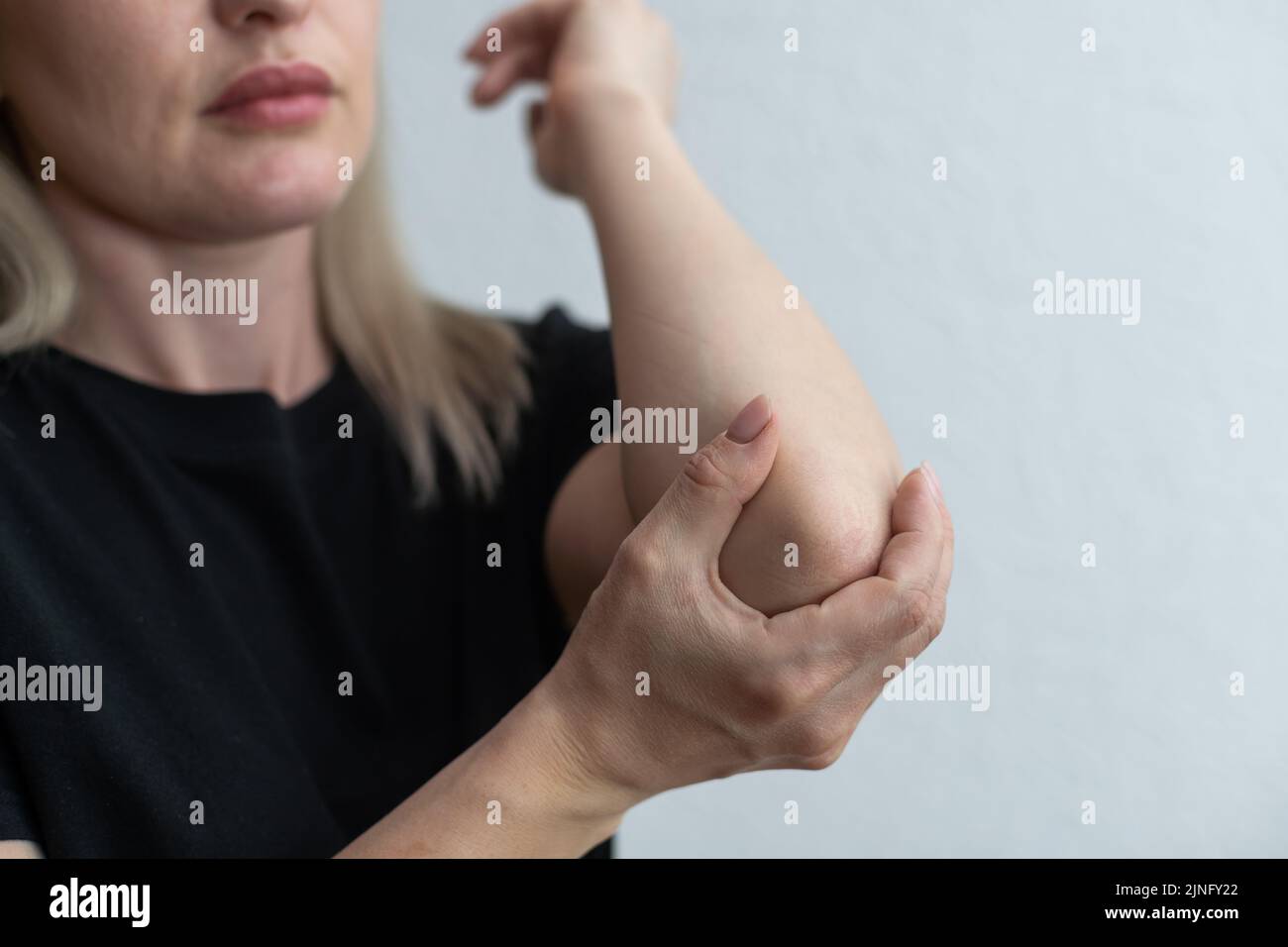 women elbow pain, holding hand to spot of elbow pain. Arm pain and ...
