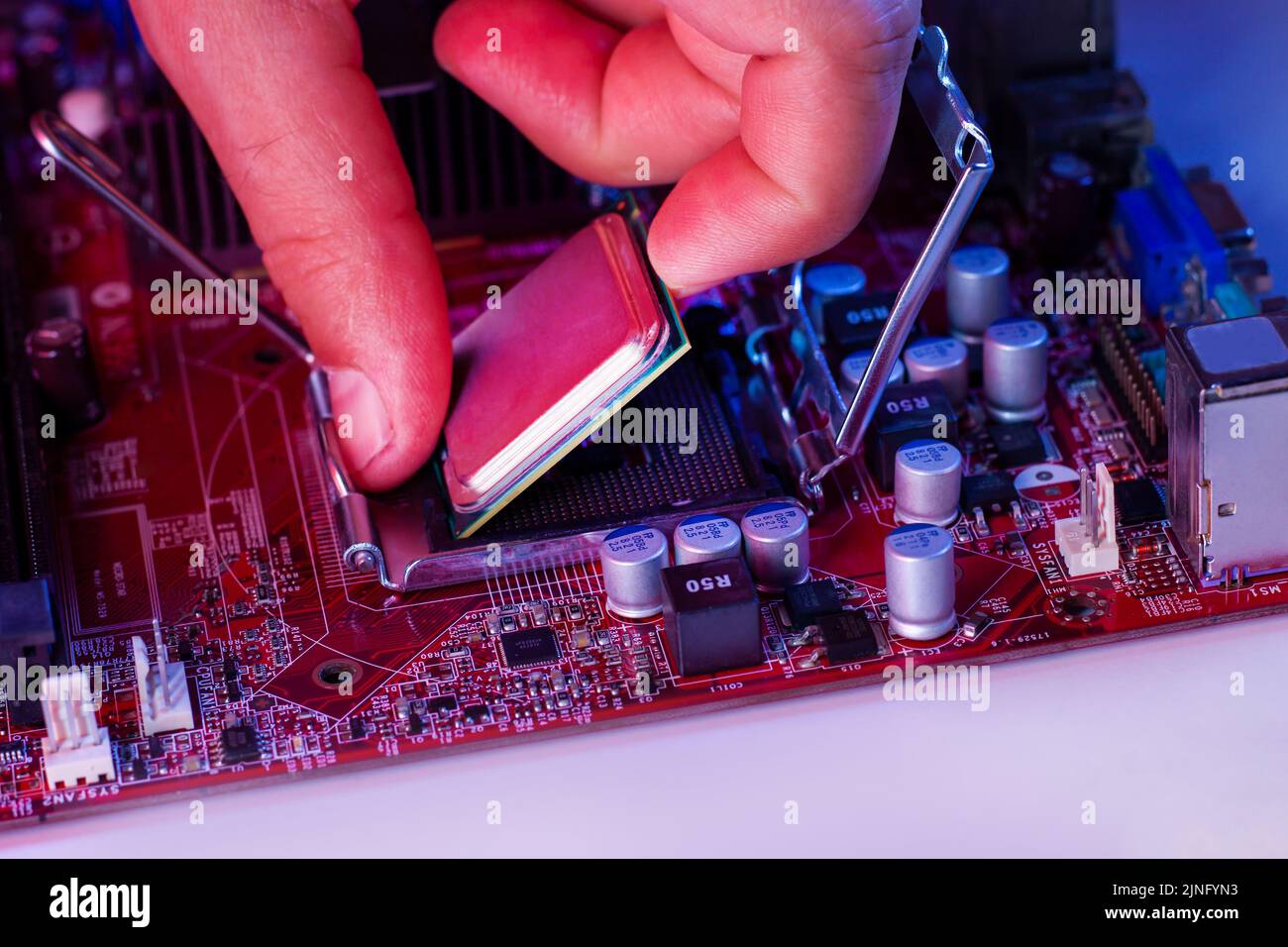 A man's hand inserts a processor into the motherboard chipset Stock ...