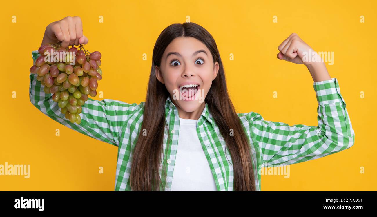 amazed child with grapes bunch on yellow background. diet Stock Photo ...