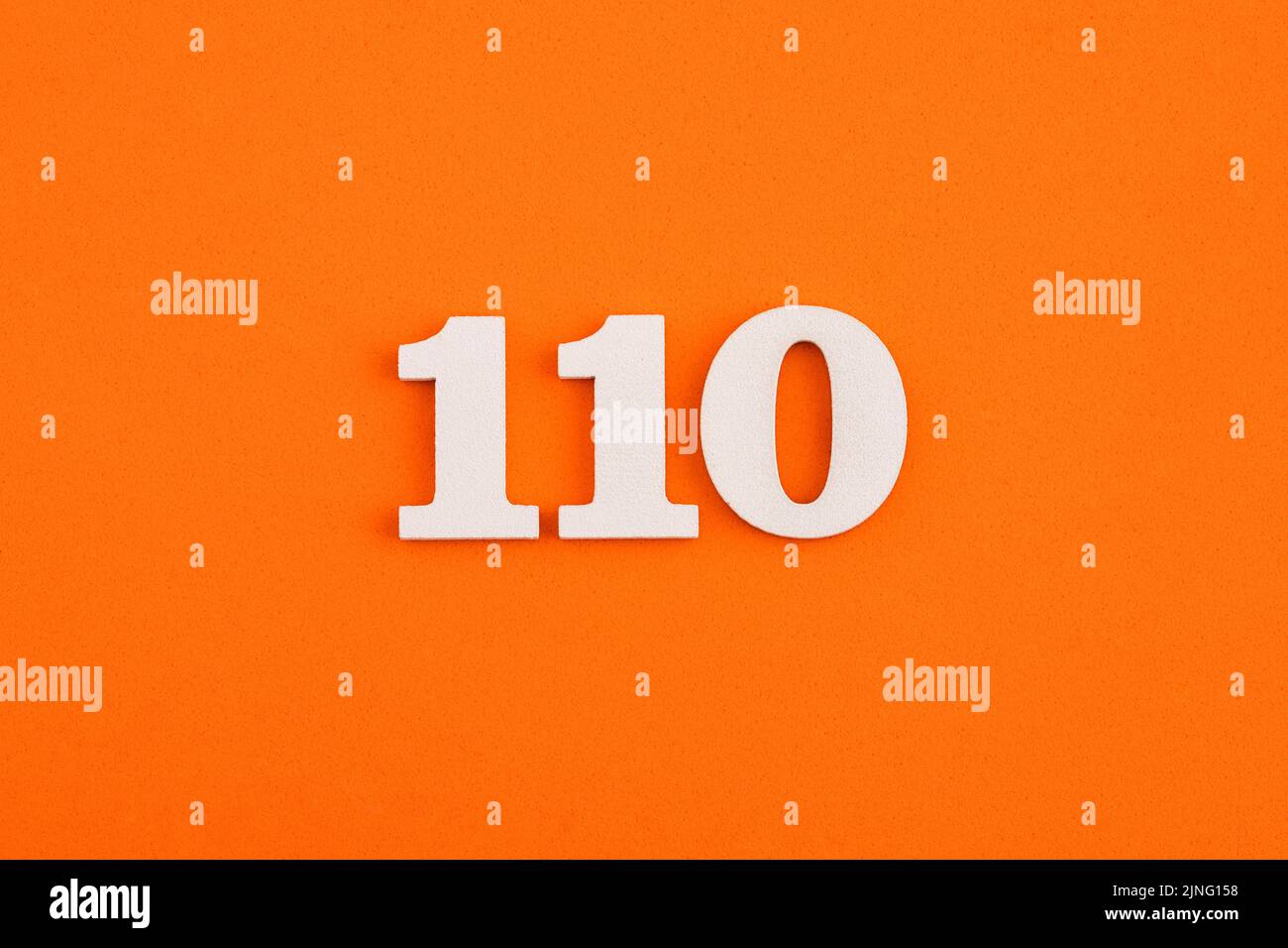 White wooden number 110 on eva rubber orange background Stock Photo - Alamy