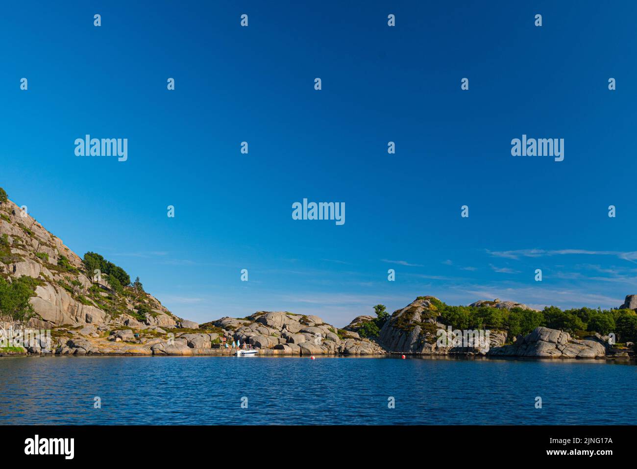 rocky cliff near blue sea water with blue sky above Stock Photo - Alamy
