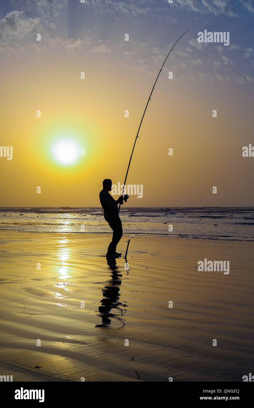 A Fisher man holding his hook with his fisher rod with a beautiful ...