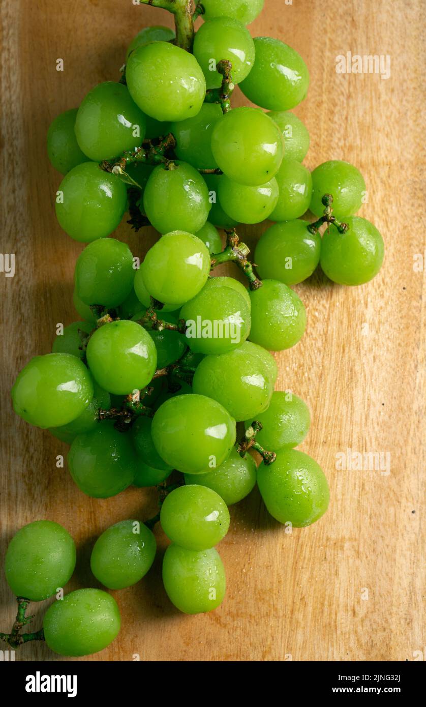 Fresh Green grapes on a wooden cutting board. Shooting in the dark ...