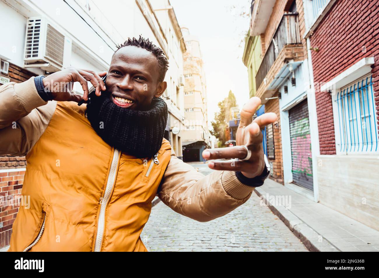 young black man of african ethnicity outdoors happy talking on the ...