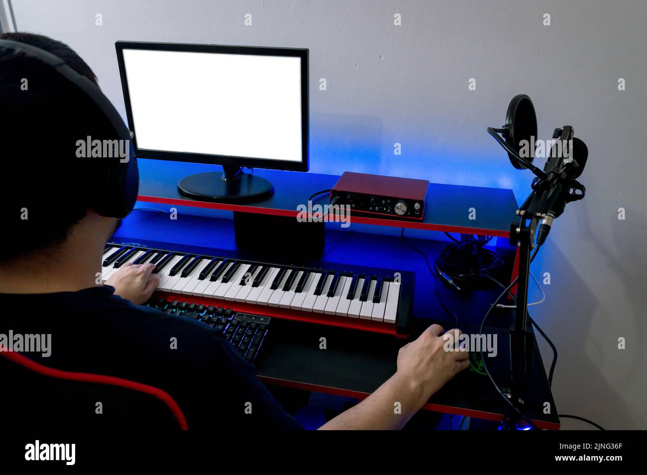 rear side view of a male sound engineer with headphones, playing the ...