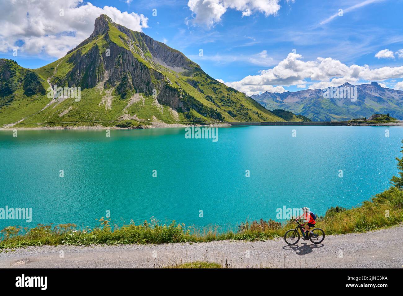 active senior woman, riding her electric mountain bike at Spuller Lake ...
