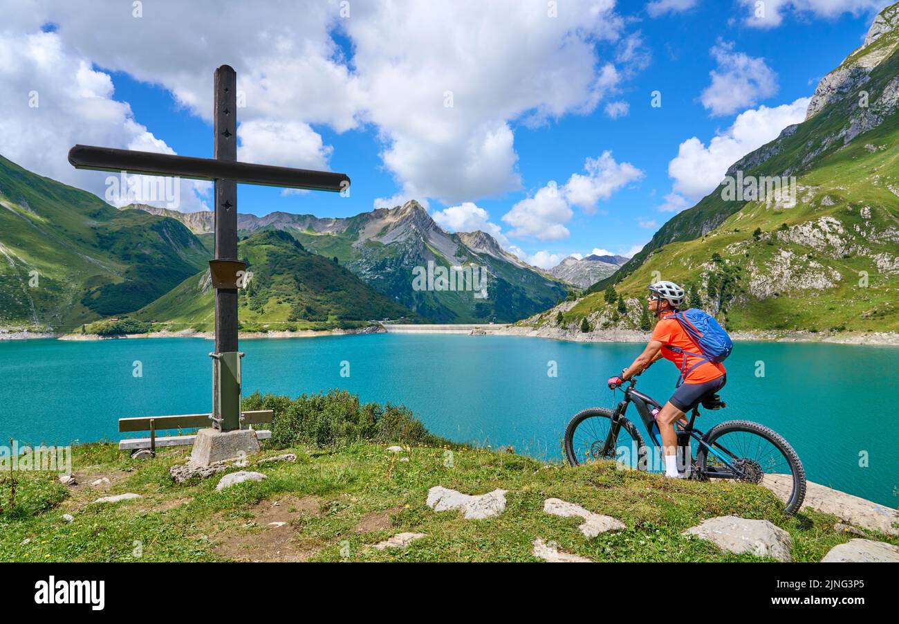 active senior woman, riding her electric mountain bike at Spuller Lake ...