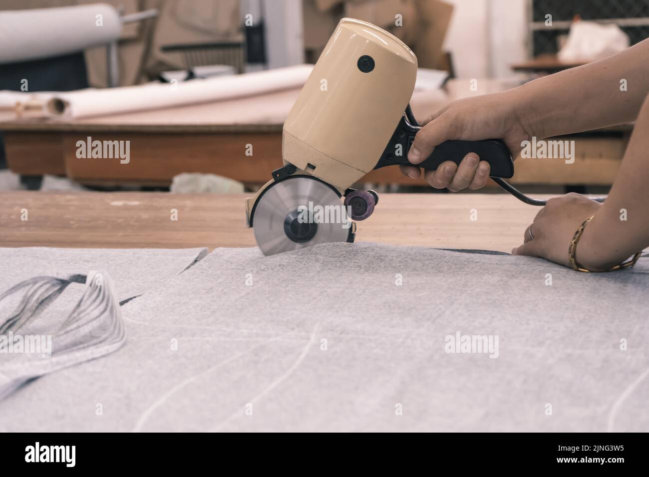 The cutter cuts the fabric with a disc cutting knife in the sewing ...