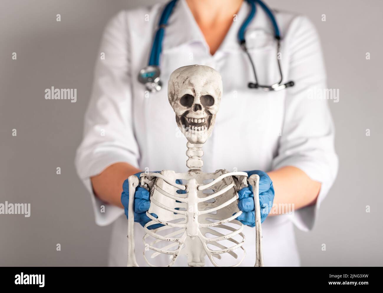 Doctor showing human skeleton. Woman in lab coat with stethoscope ...