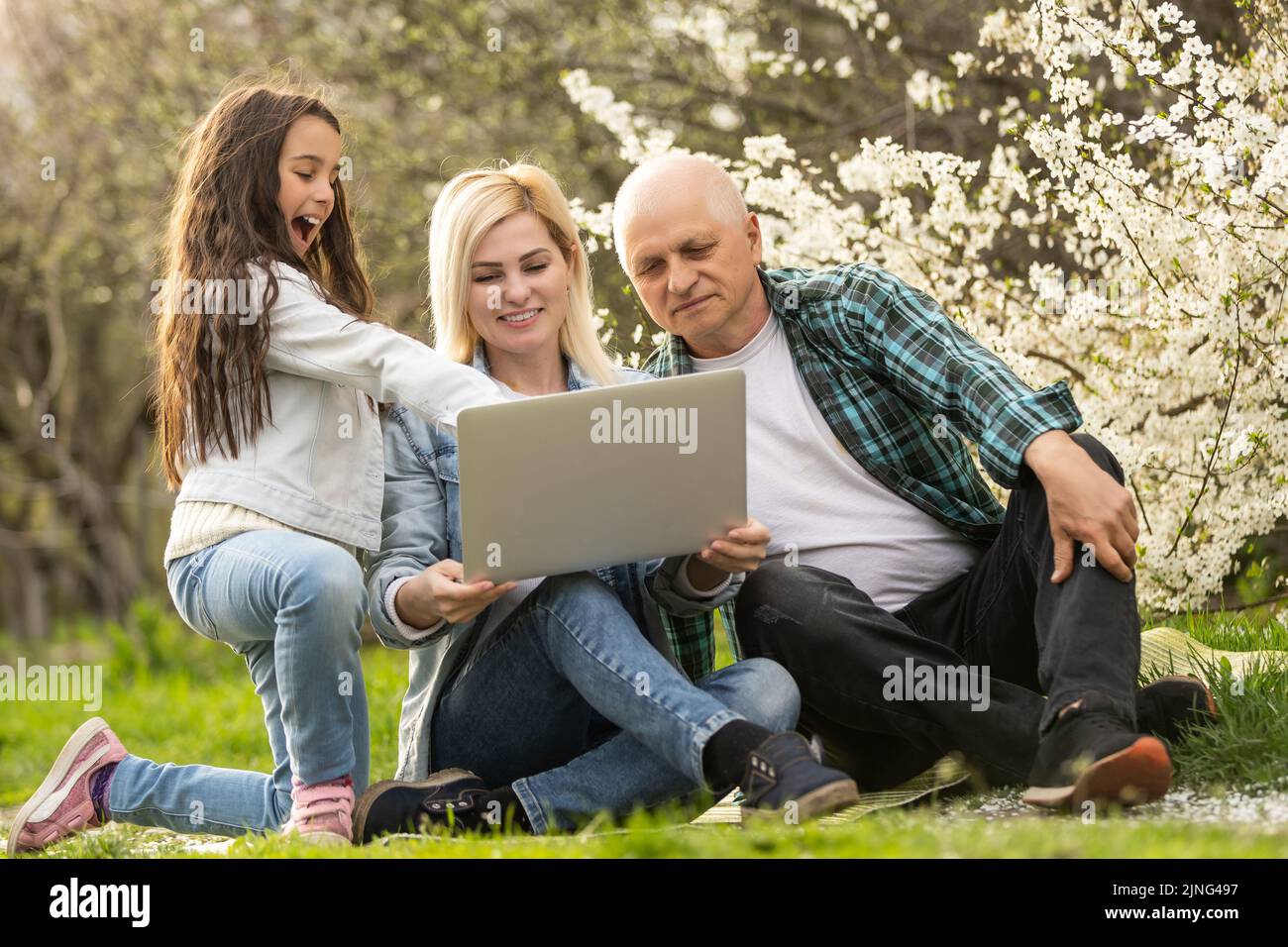 Three generation family sitting outside in spring nature Stock Photo ...