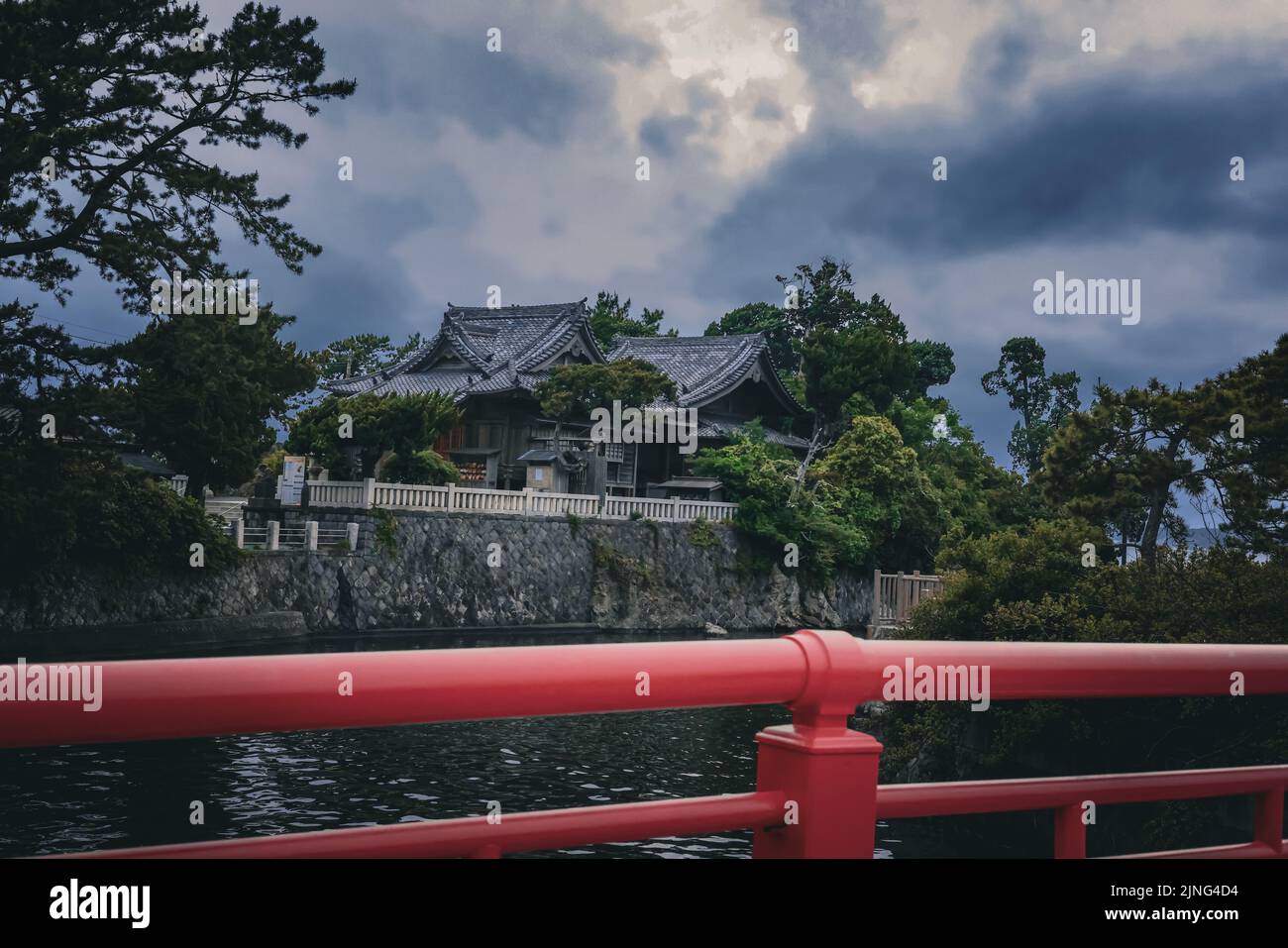 A beautiful view of a Japanese mansion near the river on a cloudy day ...