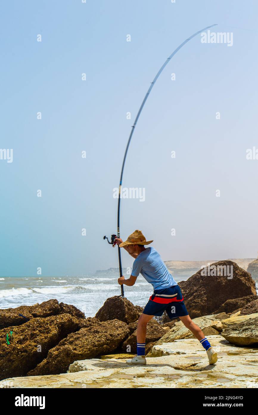 A Fisher man throwing his hook with his fisher rod with a beautiful ...