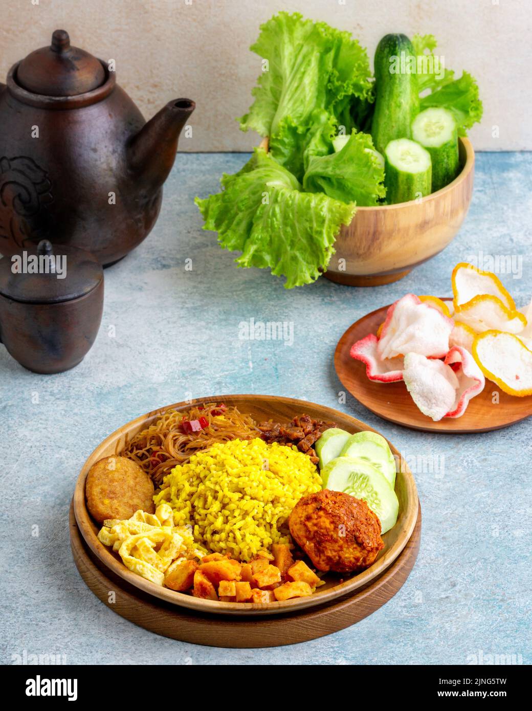 Indonesian yellow rice served with egg, vermicelli, potato fried chili ...