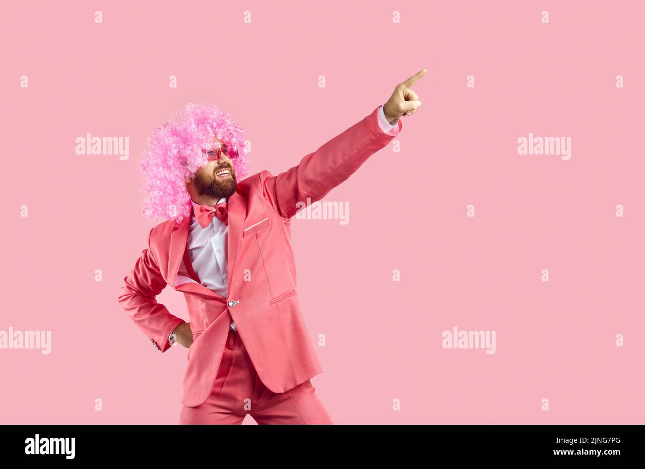 Funny man in wig point at copy space Stock Photo - Alamy