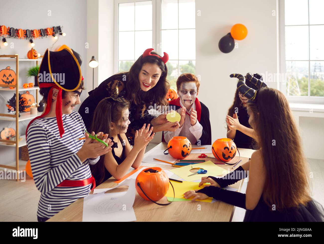 Teacher learn with kids dressed for Halloween eve Stock Photo - Alamy