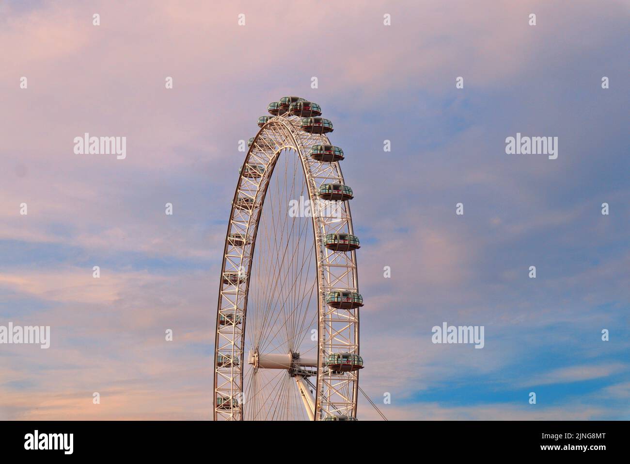 A breathtaking shot of the London Eye with sunset pink clouds in the ...