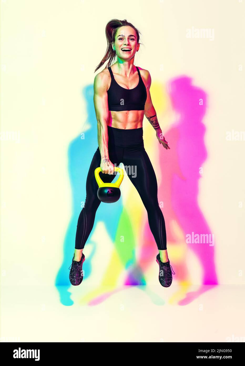 Strong woman jumping with kettlebell. Photo of sporty woman in black ...