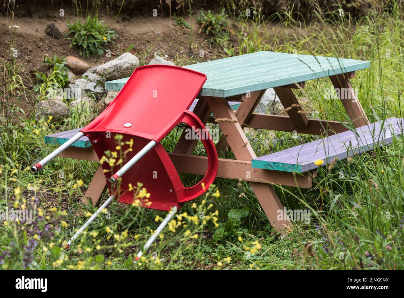Painted bench and red plastic chair in NE Turkish garden Stock Photo ...