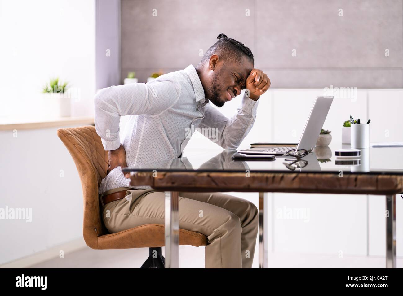 Back Pain Bad Posture Man Sitting In Office Stock Photo - Alamy