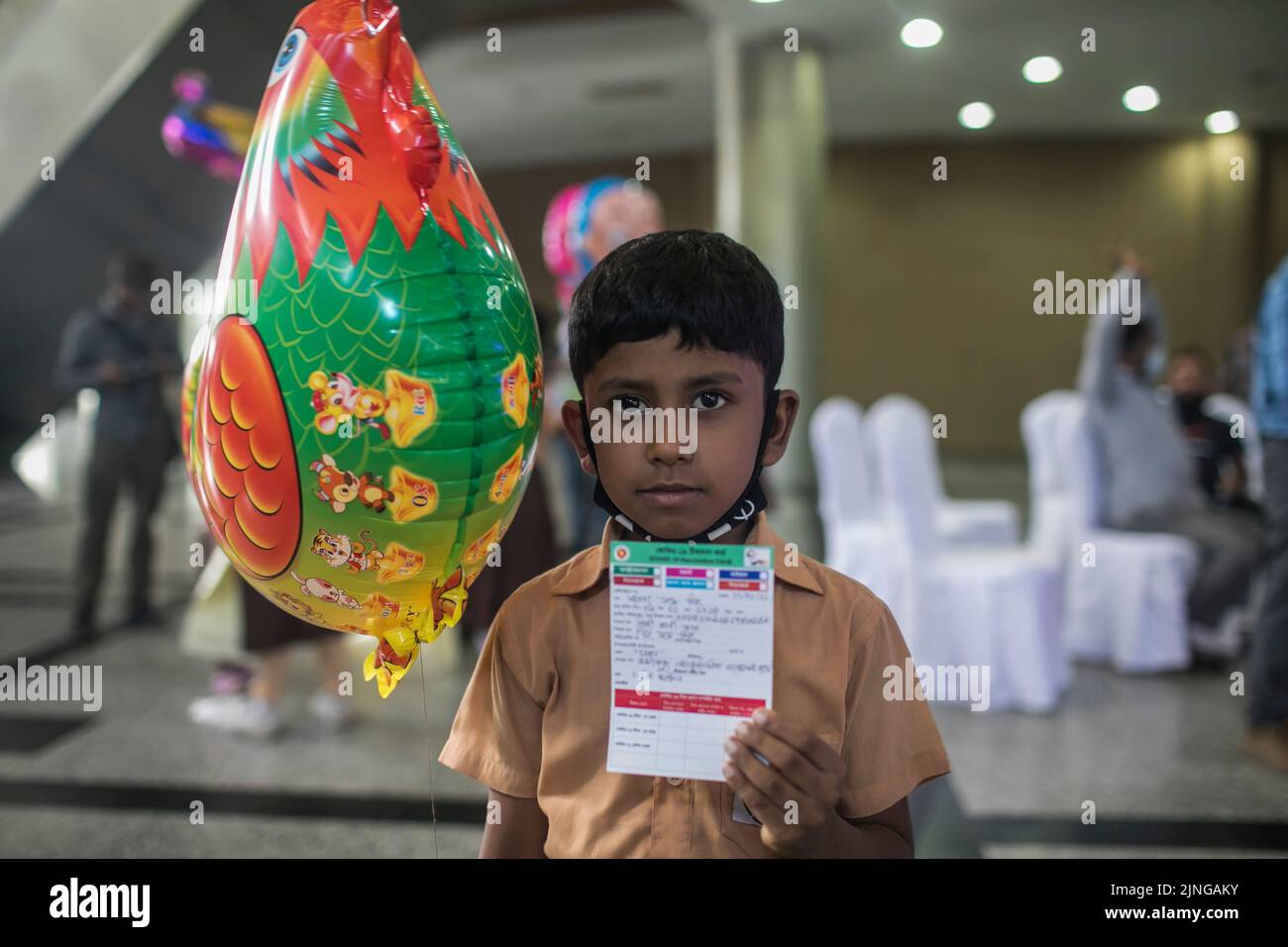 A boy shows his vaccination card after receiving a dose of Pfizer ...