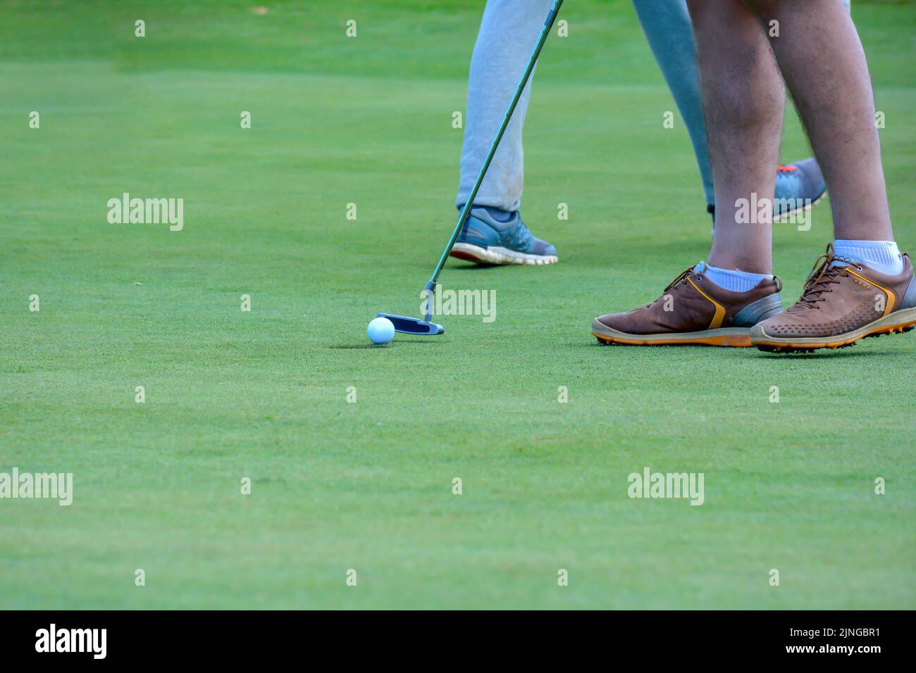 The picture shows a Golf player while hitting the ball from tee Stock ...