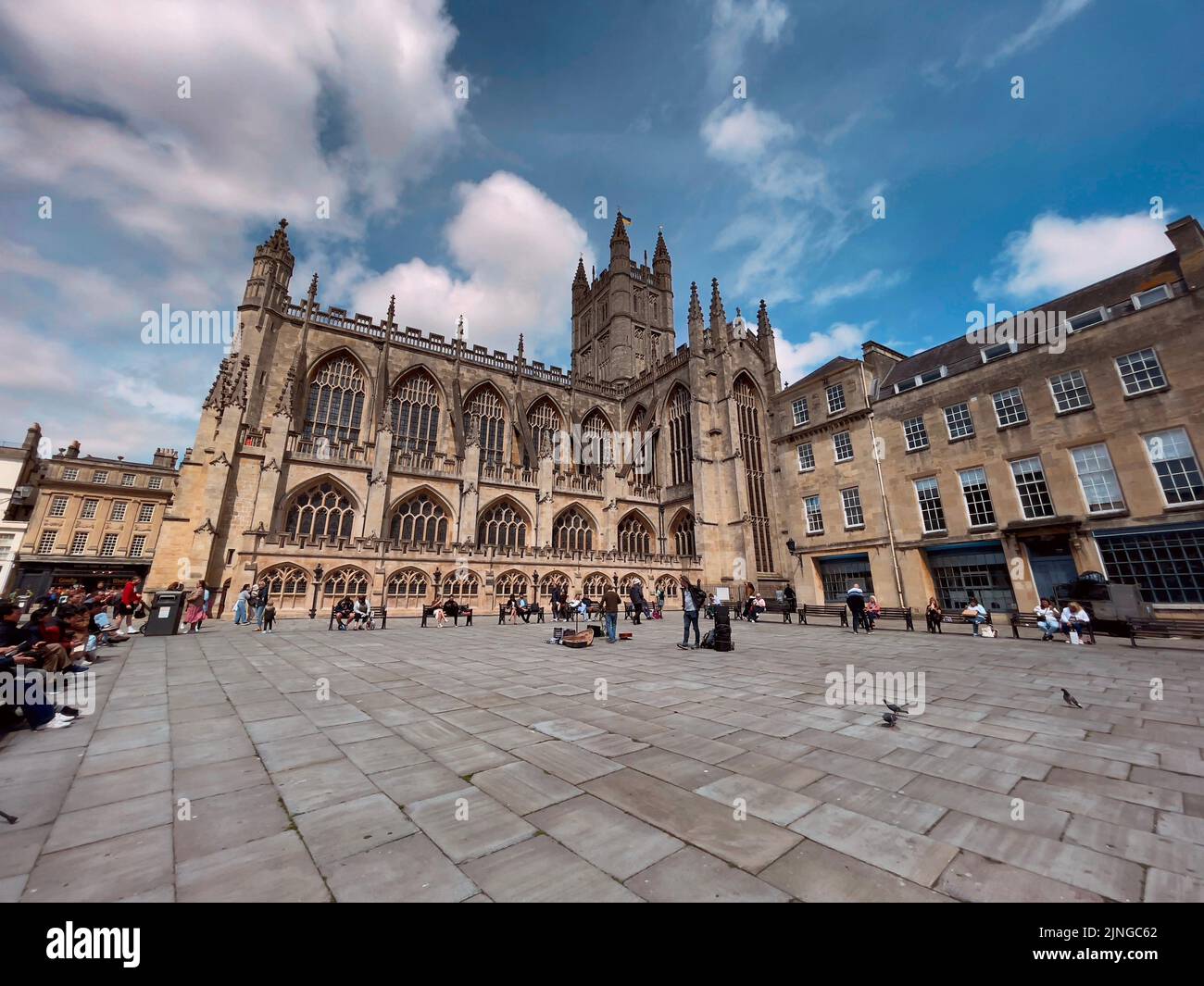 The tourists visiting Bath Abbey in Bath, England against blue cloudy ...