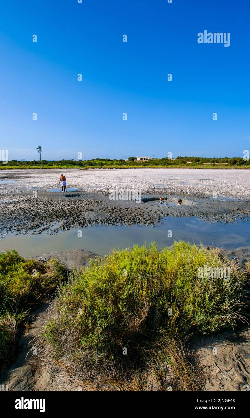 People enjoy a mud bath in Espalmador, a small island located in the ...