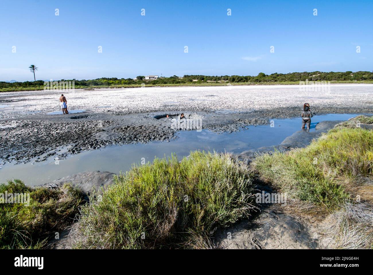People enjoy a mud bath in Espalmador, a small island located in the ...